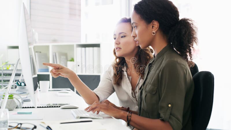 Teamwork Gets Results. Two Young Businesswomen Using a Computer ...