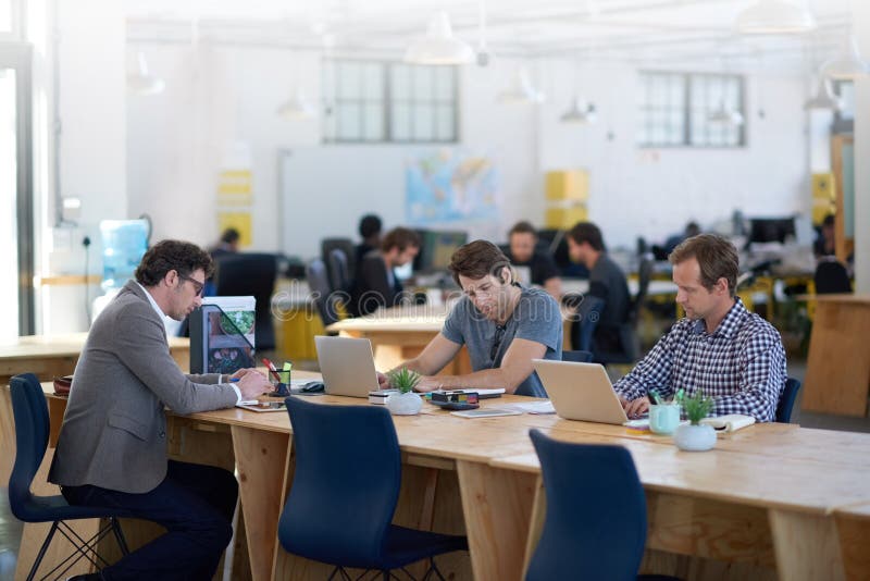 Teamwork and Ideas in Action. Colleagues Working on Laptops at a Desk ...