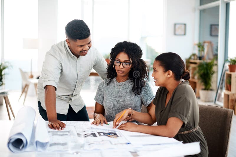 Teamwork Makes the Blueprint Work. a Group of Young Businesspeople ...