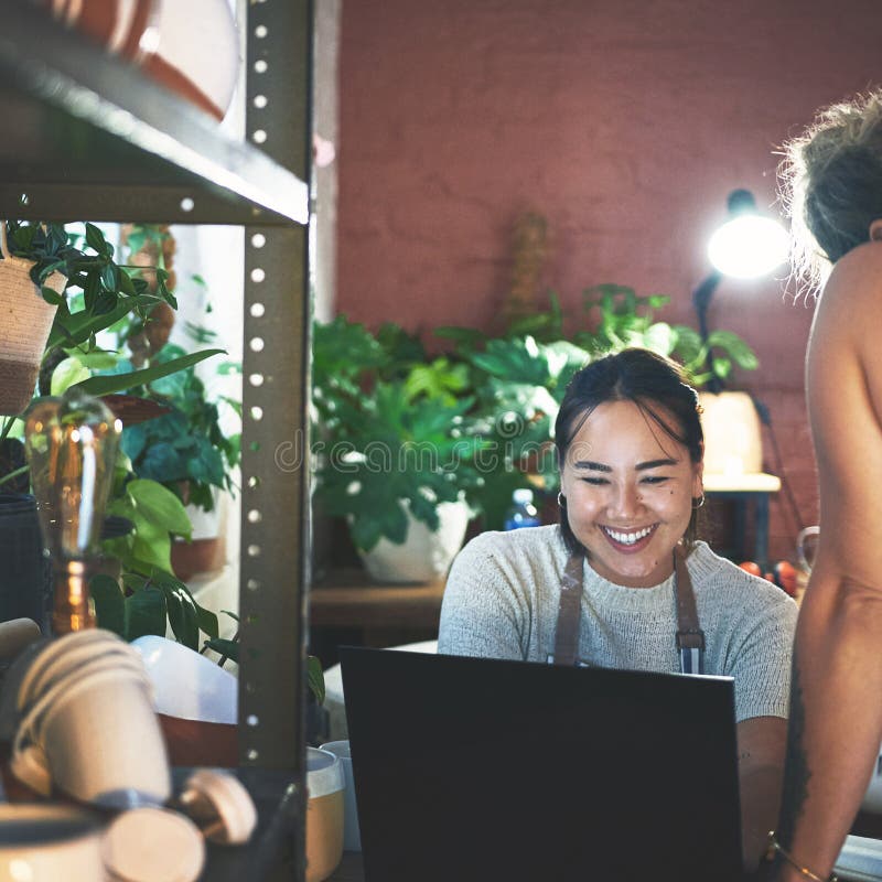 Teamwork Makes the Studio Work. Two Young Women Using a Laptop while Working Together in a ...