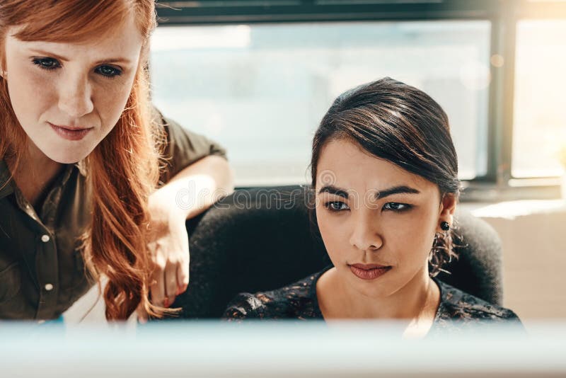 Teamwork Makes the Task Work. Two Young Businesswomen Using a Computer ...