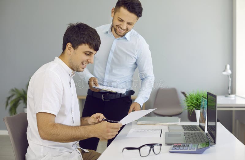 Cheerful Colleagues are Reviewing and Discussing Paper Documents while ...