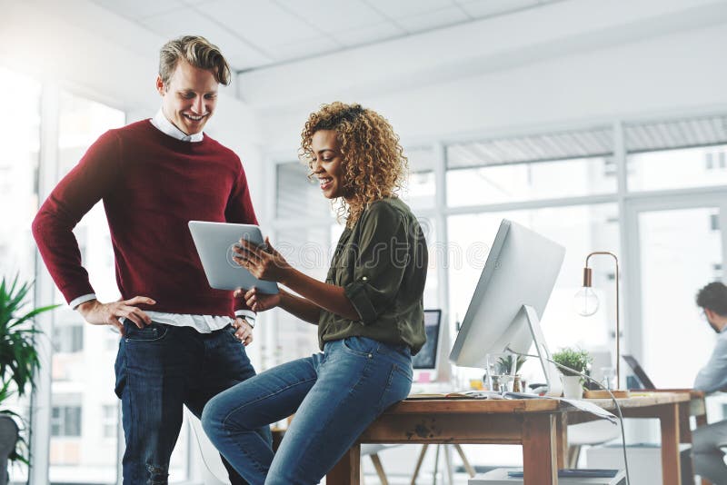 Teamwork and Tech Gets Things Done. Two Young Colleagues Using a ...