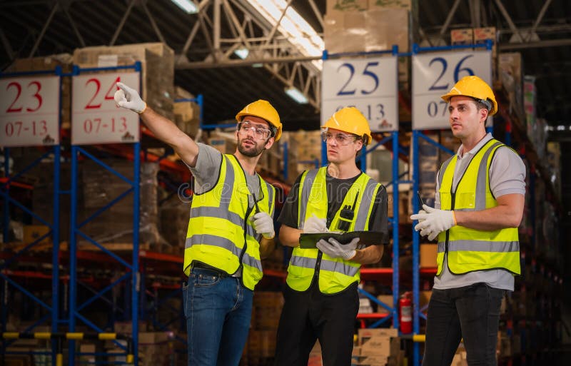 Teamwork of Three Warehouse Workers in Uniform Wearing Yellow Safety ... Teamwork of Three Warehouse Workers in Uniform Wearing Yellow Safety ...
