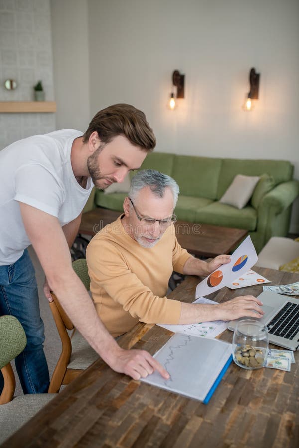 Two Men Working Together on a Project and Looking Involved Stock Photo ...