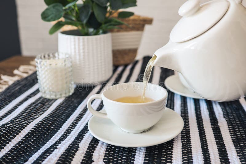Teapot Pours Tea into a Cup, Tea Drinking Concept Stock Photo - Image ...