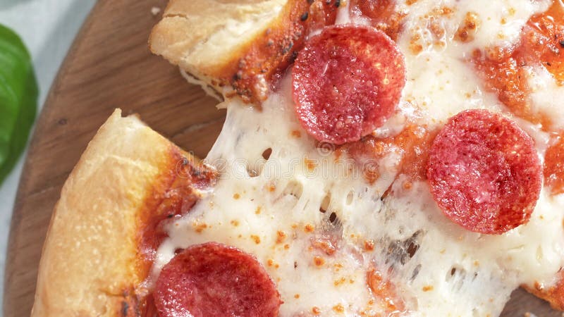 Tearing a Slice of Pepperoni Pizza - Table Top View of Stretchy ...