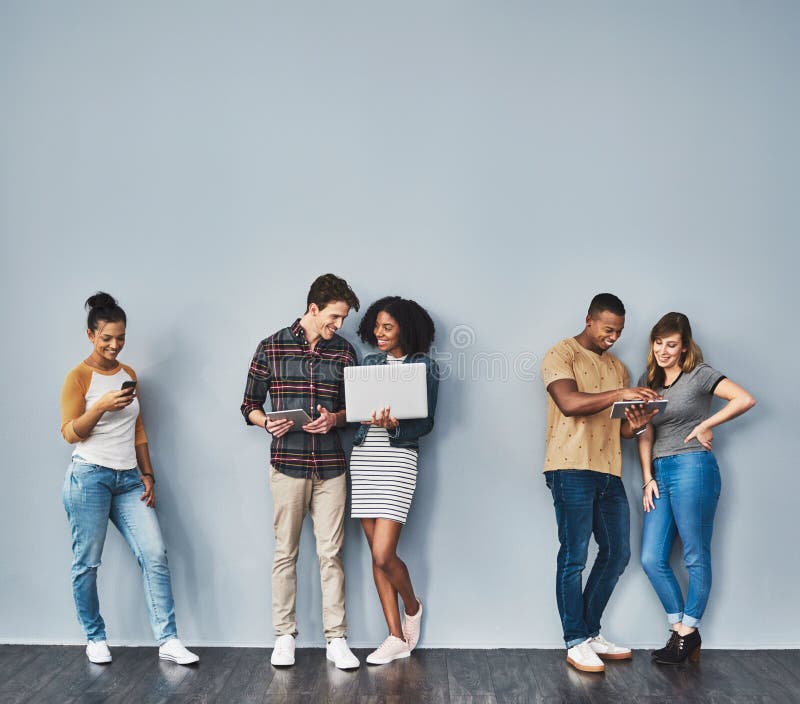 The Tech Savvy Generation. Studio Shot of a Group of Young People Using ...