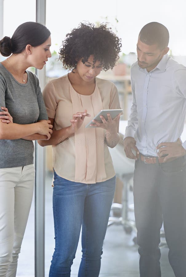 Tech Savvy Team Mates. a Group of Colleagues Using a Digital Tablet ... Tech Savvy Team Mates. a Group of Colleagues Using a Digital Tablet ...