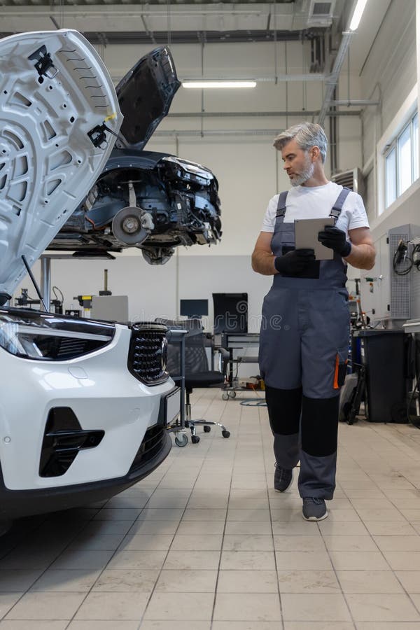 Technician in Auto Shop Using Advanced Technology for Inspection and ...