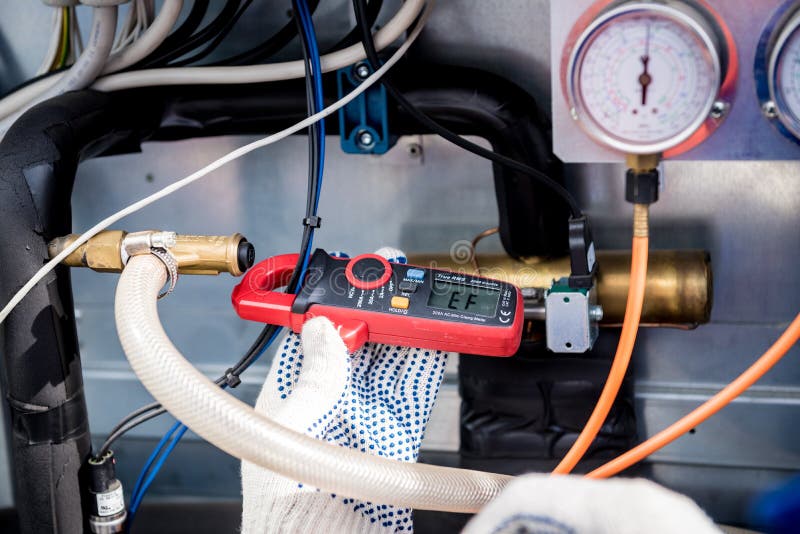 The Technician Checking Power Lines of the Heat Exchanger with Current ...