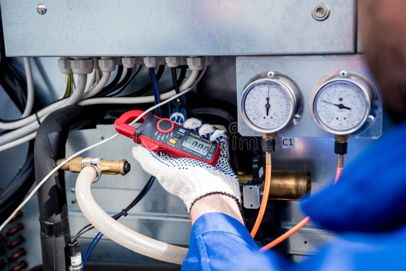 The Technician Checking Power Lines of the Heat Exchanger with Current ...