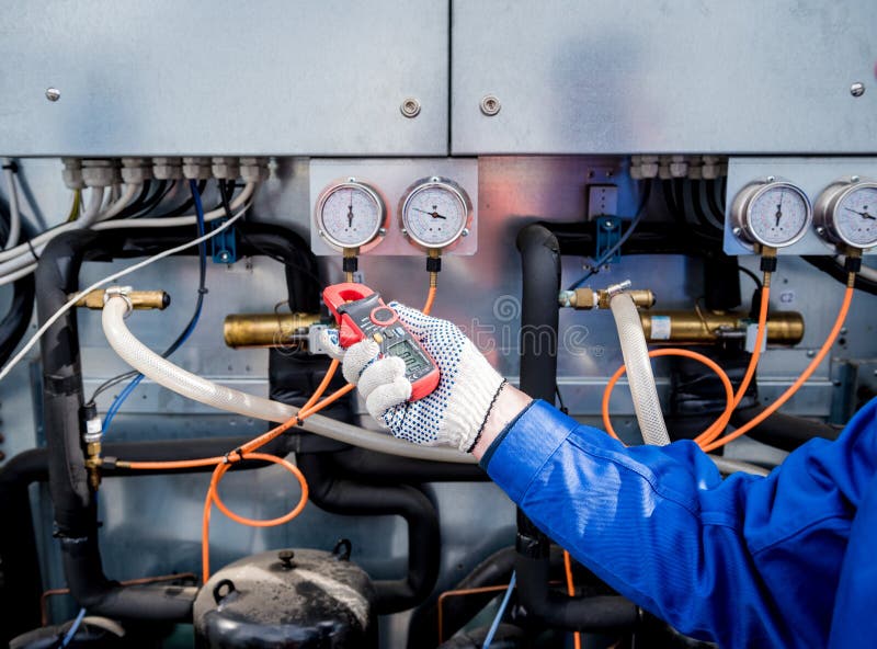 The Technician Checking Power Lines of the Heat Exchanger with Current ...
