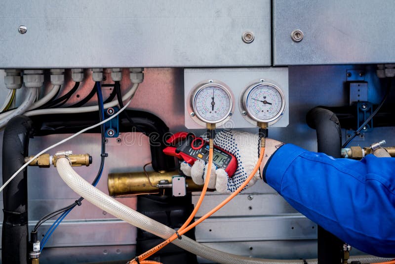 The Technician Checking Power Lines of the Heat Exchanger with Current ...