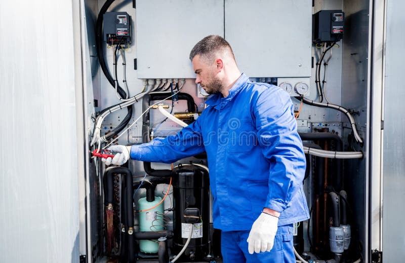 The Technician Checking Power Lines of the Heat Exchanger with Current ...