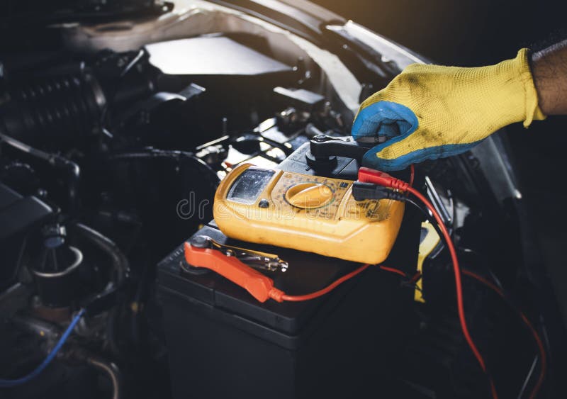 Technician Clamping Jumper Cable for Checking Car Battery Voltage with ...