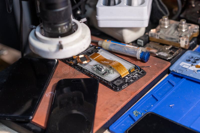 A Technician Conducts a Battery Replacement for a Mobile Phone on a ...