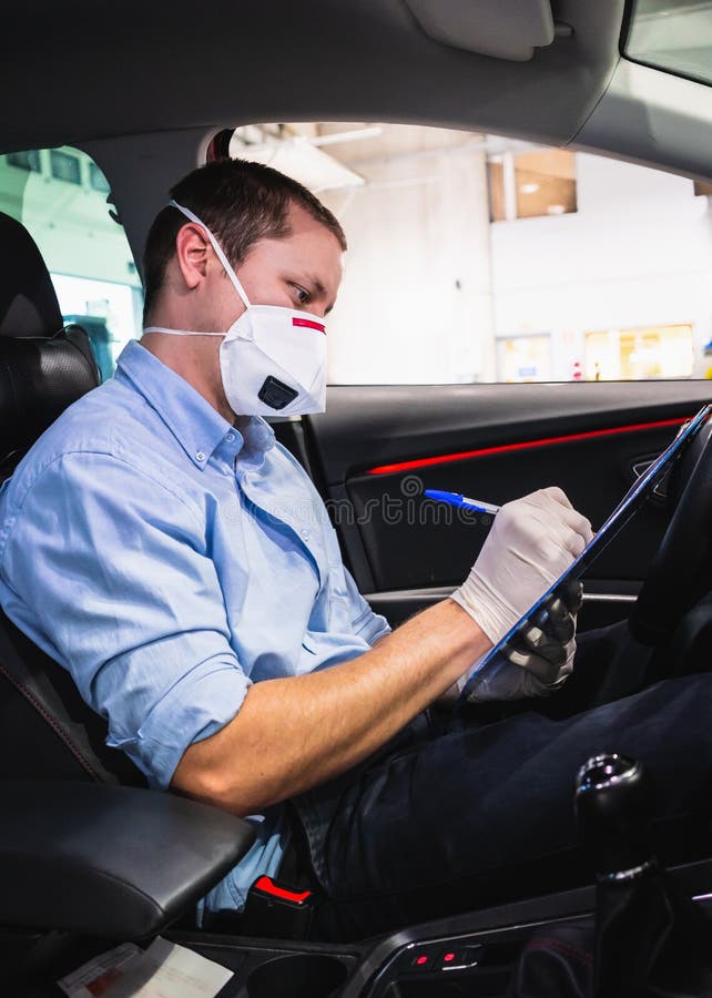Technician Doing a Security Inspection Inside a Vehicle Protected with ...
