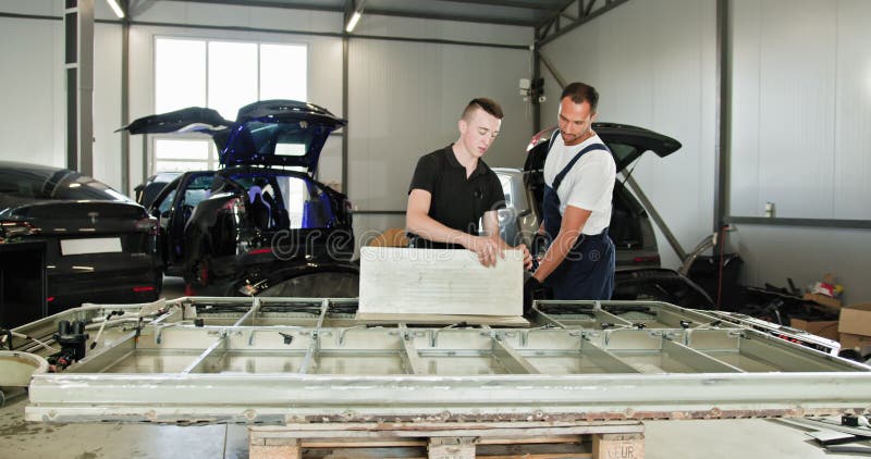Technicians Working on Electric Car Battery Module in Workshop Stock ...