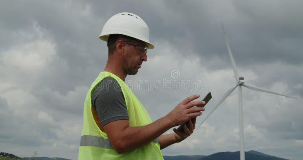 Technician Engineer Working at Wind Turbine Using Laptop Computer ...