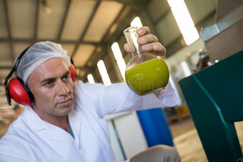 Technician Examining Olive Oil Produced from Machine Stock Photo ...