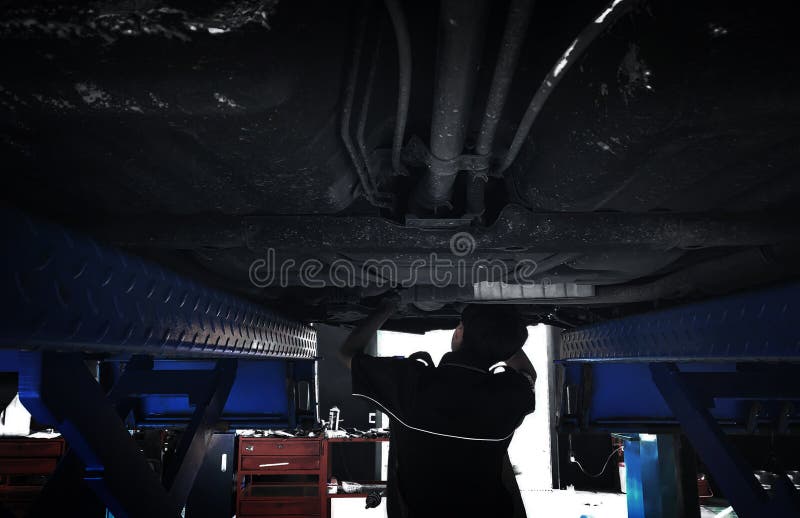 Technician Fixing Auto Car Service from Under Lift at Garage Stock ...