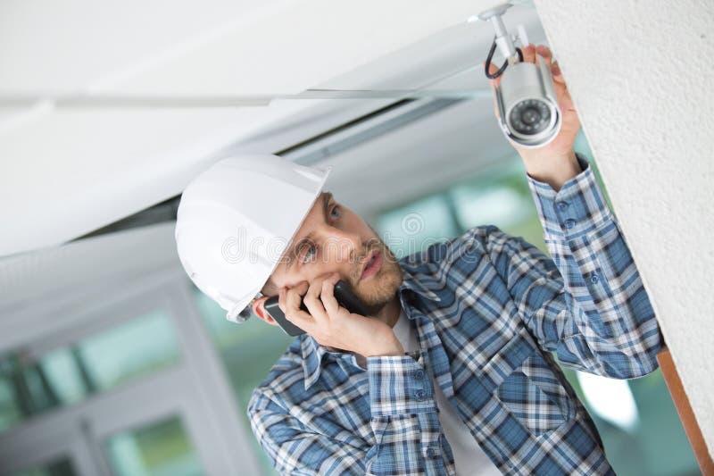 Technician Fixing Cctv Camera on Wall and Phoning for Help Stock Photo ...