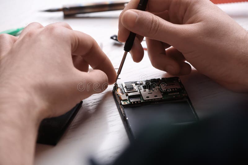 Technician Fixing Mobile Phone at Table. Device Repair Service Stock ...