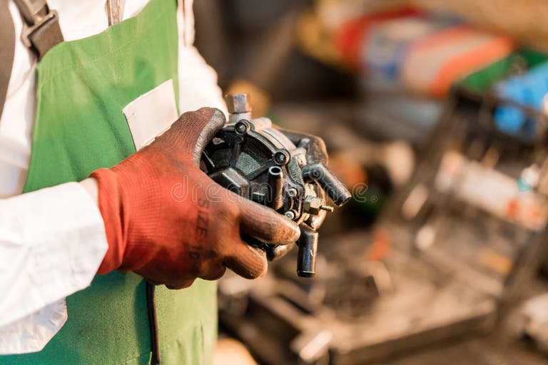 A Technician Holding a Mechanical Component in a Workshop Setting Stock ...