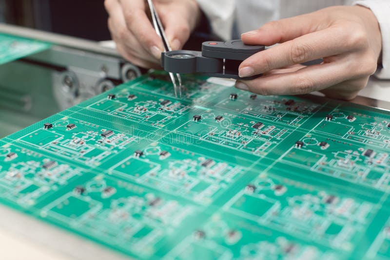 Technician Inserting Electronic Components into a PDB for Assembly ...