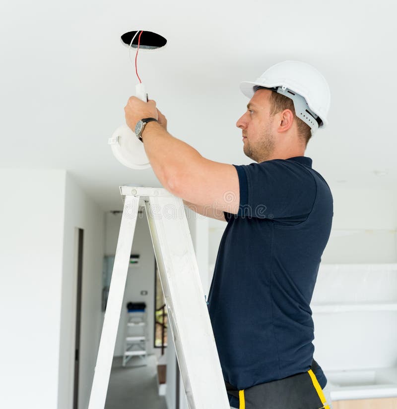 Technician is Installing an LED Spotlight in the Ceiling. Stock Photo ...