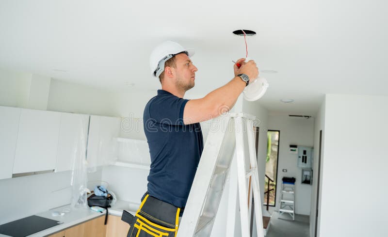 Technician is Installing an LED Spotlight in the Ceiling. Stock Photo ...