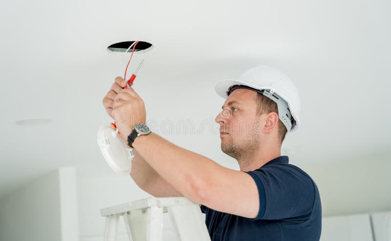 Technician is Installing an LED Spotlight in the Ceiling. Stock Image ...