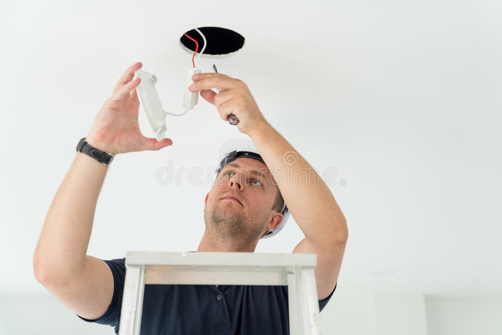 Technician is Installing an LED Spotlight in the Ceiling. Stock Photo ...
