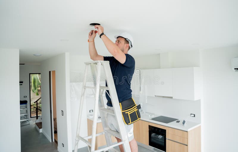 Technician is Installing an LED Spotlight in the Ceiling. Stock Photo ...