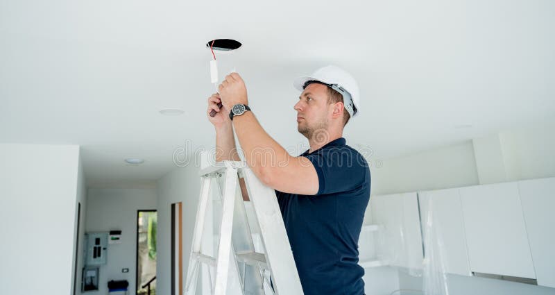 Technician is Installing an LED Spotlight in the Ceiling. Stock Photo ...