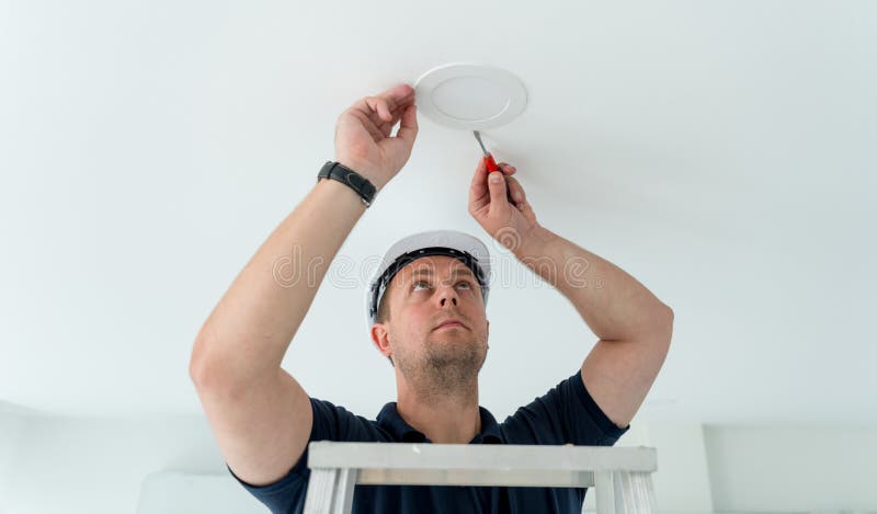 Technician is Installing an LED Spotlight in the Ceiling. Stock Photo ...