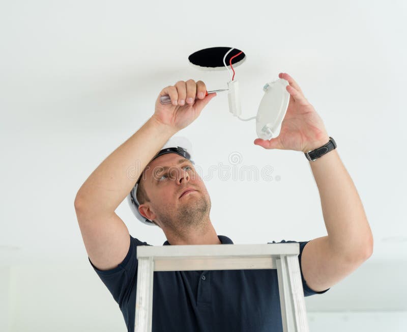 Technician is Installing an LED Spotlight in the Ceiling. Stock Photo ...