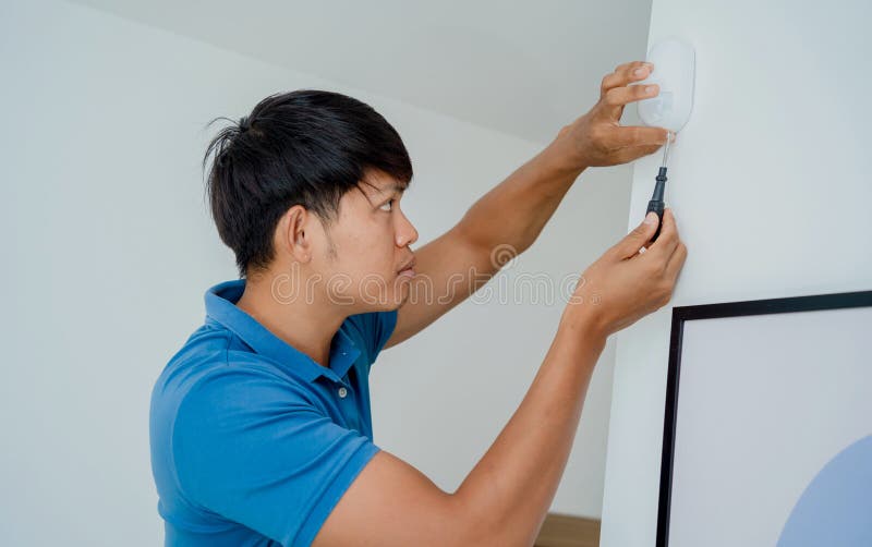 A Technician Installing Motion Sensor Detector in a Modern Apartment ...