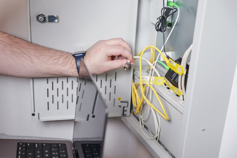 Technician Installing Network Cable in Server Cabinet while Configuring ...