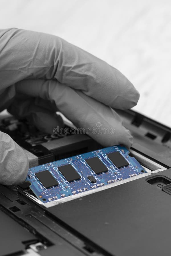 Technician Installing RAM into the Memory Slot on a Laptop Computer ...