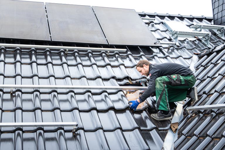 Technician Installing a Solar Panel Array on the Roof of a House Stock ...