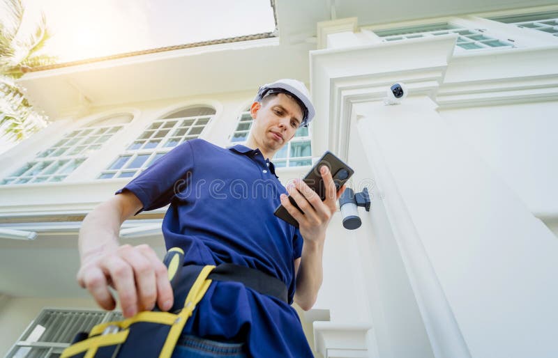 A Technician Installs a CCTV Camera on the Facade of a Residential ...