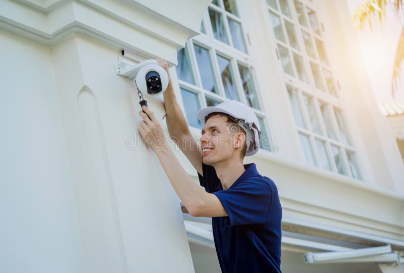 A Technician Installs a CCTV Camera on the Facade of a Residential ...