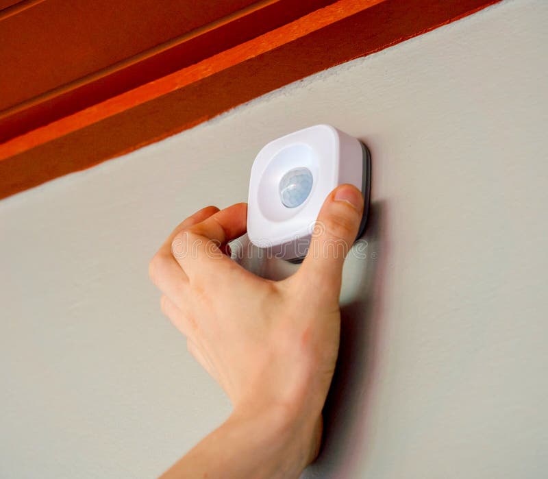 A Technician Installs a Modern Movement Detector in a Cozy Apartment ...
