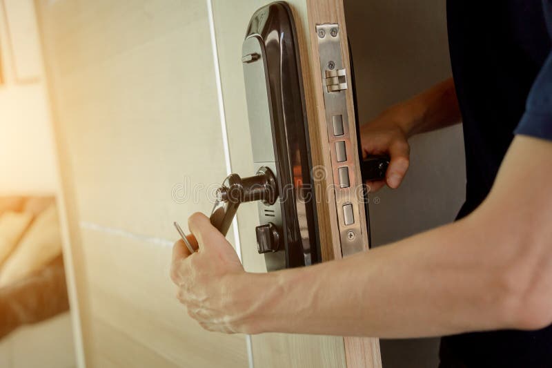A Technician Installs a Modern Smart Door Lock on the Wood Door Stock ...