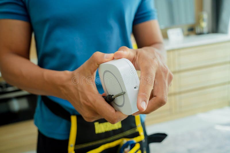 A Technician Installs a Security Alarm Siren in a Modern Apartment ...