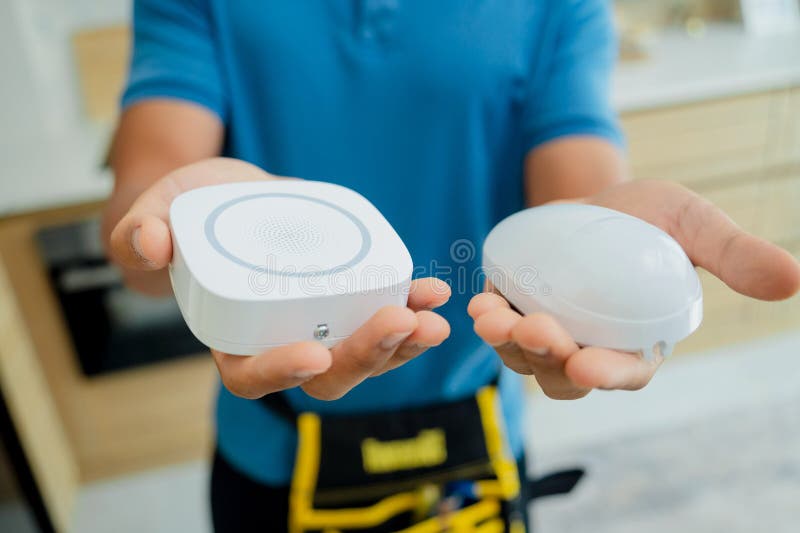 A Technician Installs a Security Alarm Siren and Motion Sensor Detector ...