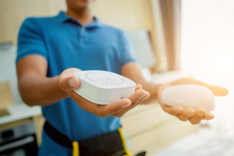A Technician Installs a Security Alarm Siren and Motion Sensor Detector ...