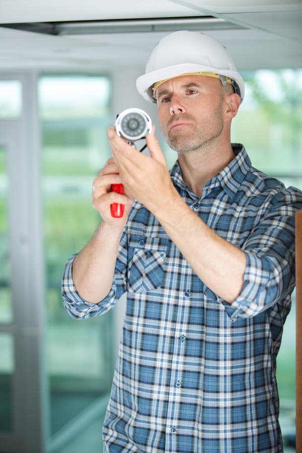 Man Looking at Security Camera and Making Phonecall Stock Image - Image ...